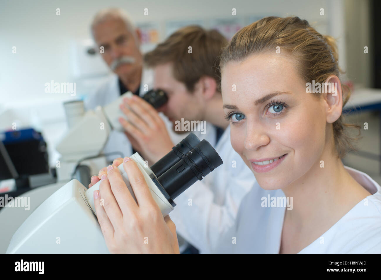 team of scientists in a laboratory working with microscopes Stock Photo - Alamy