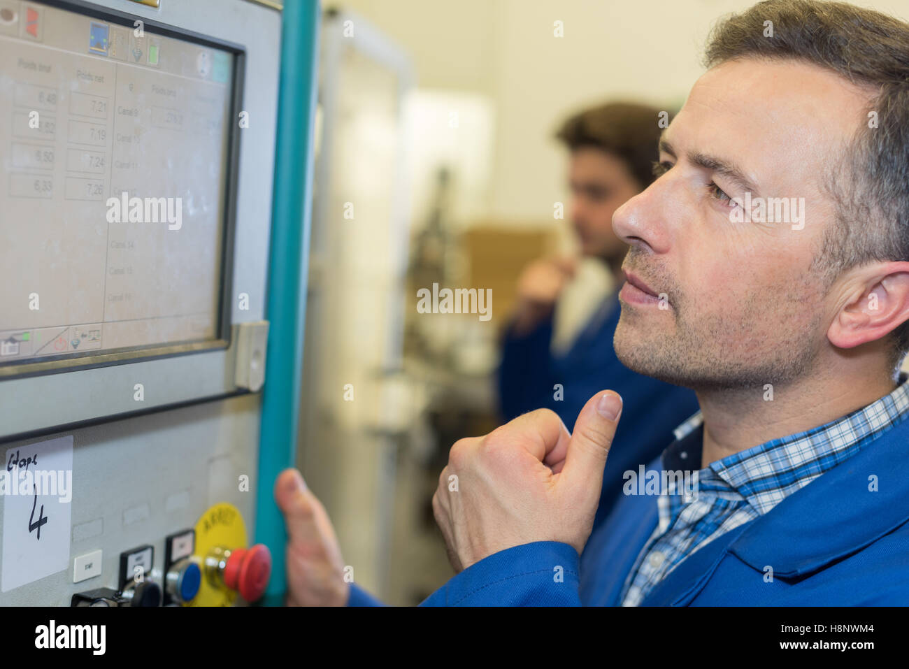 man worker checking advanced industrial control panel Stock Photo - Alamy