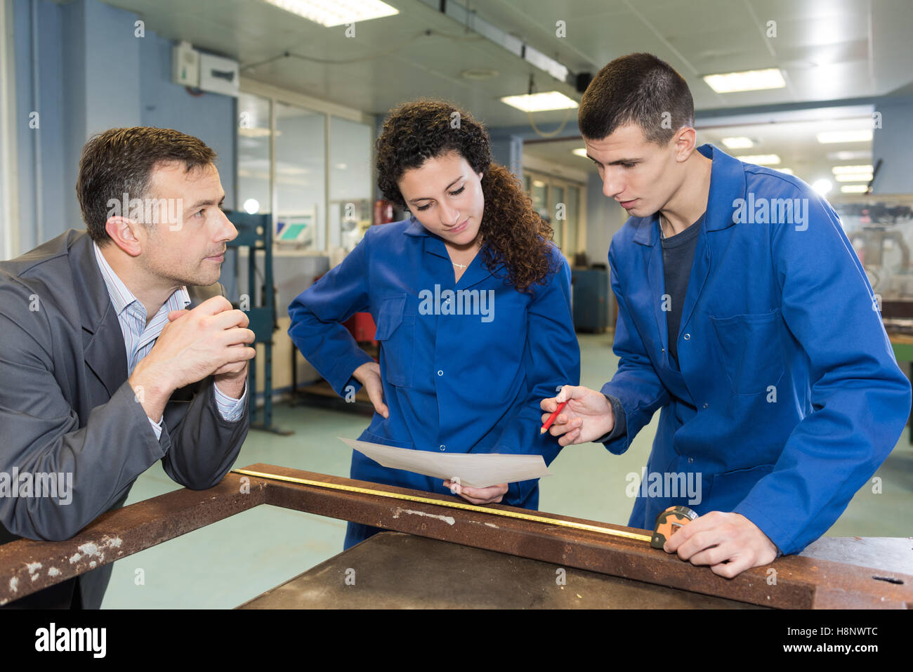 Students measuring wood according to plans Stock Photo - Alamy
