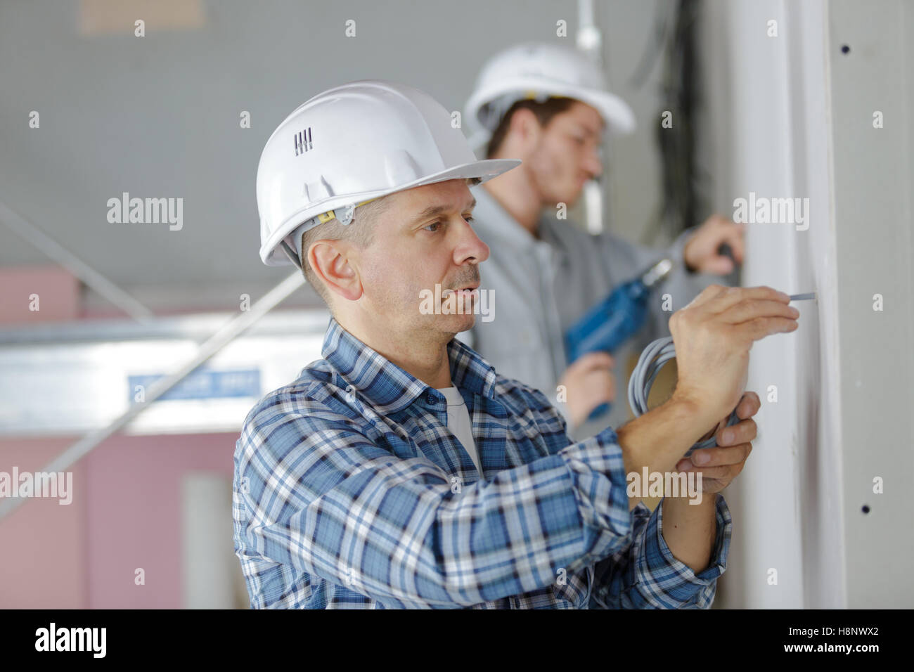 men drilling the wall with drill perforator Stock Photo - Alamy