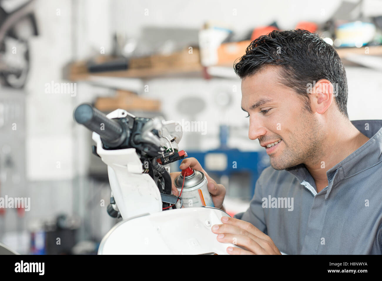 Mechanic working on a scooter Stock Photo - Alamy
