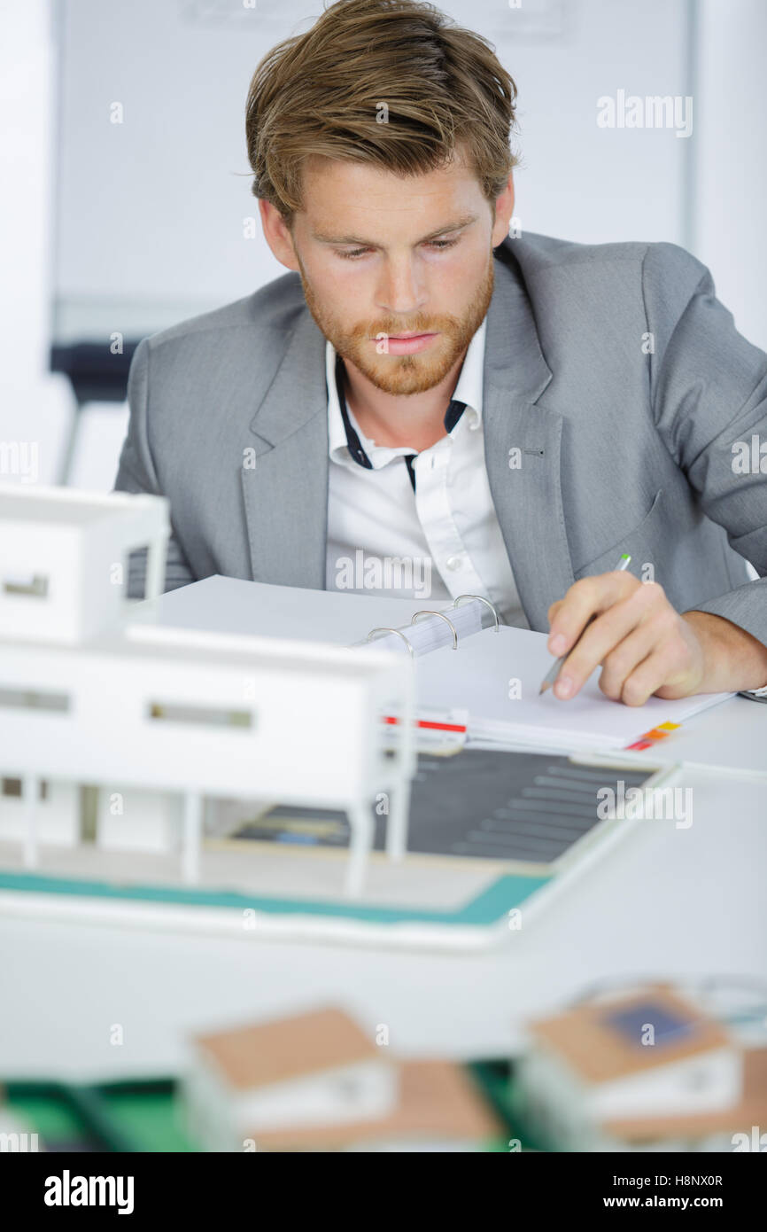 happy businessman with house model by a desk Stock Photo - Alamy
