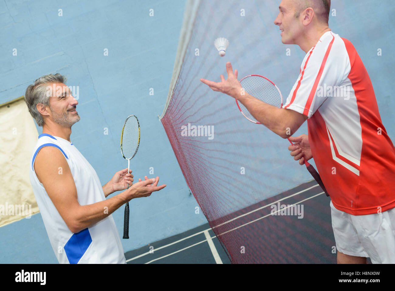 happy couple playing badminton togheter indoors Stock Photo - Alamy