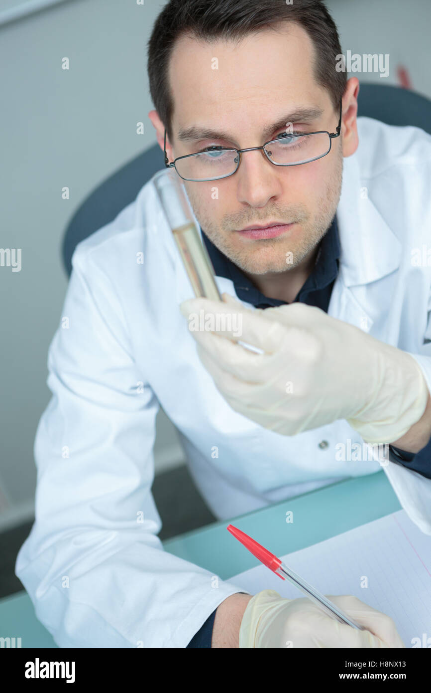 scientist looking at glass tube in lab Stock Photo - Alamy
