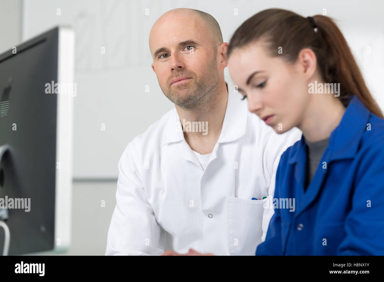 two workers sitting opposite a computer Stock Photo - Alamy