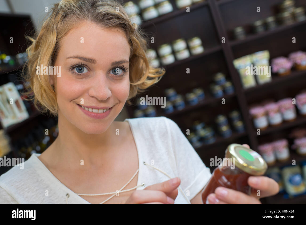 female customer holding a jar of jam Stock Photo - Alamy