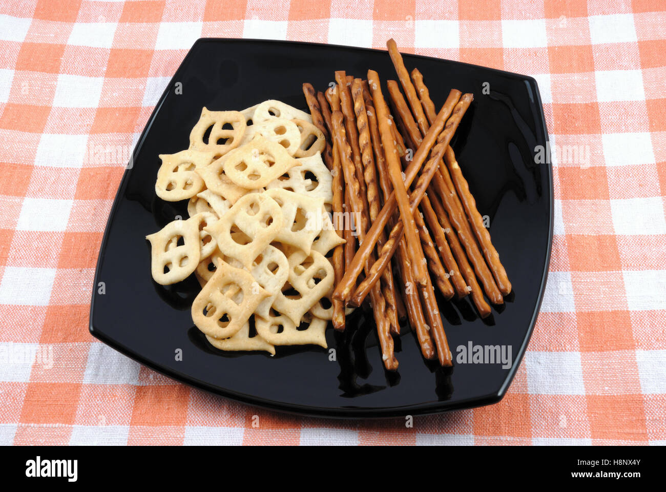 Mini crackers and salty grain sticks to beer on a black plate Stock ...