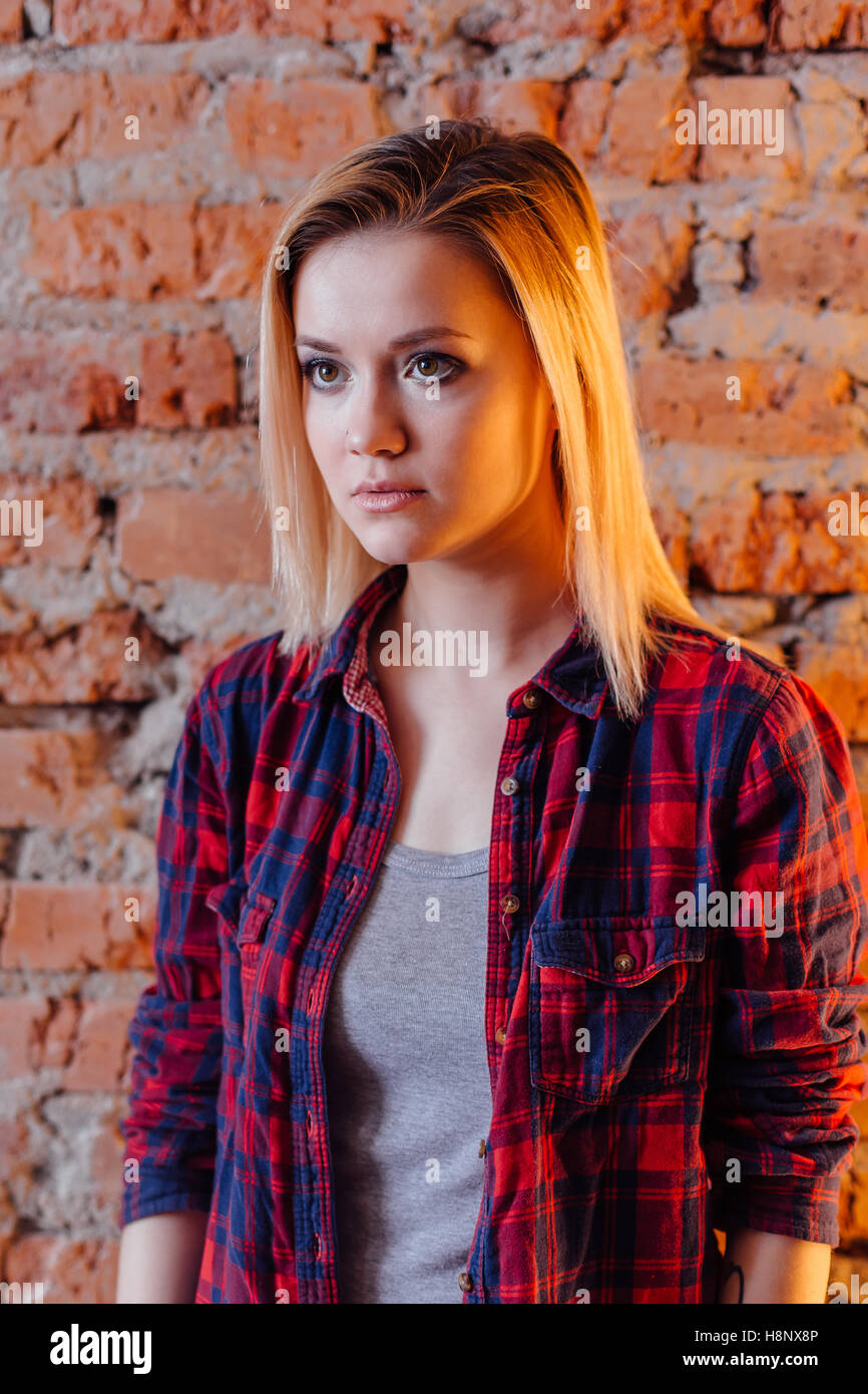 Pretty hipster girl near the brick wall in loft style room Stock Photo ...