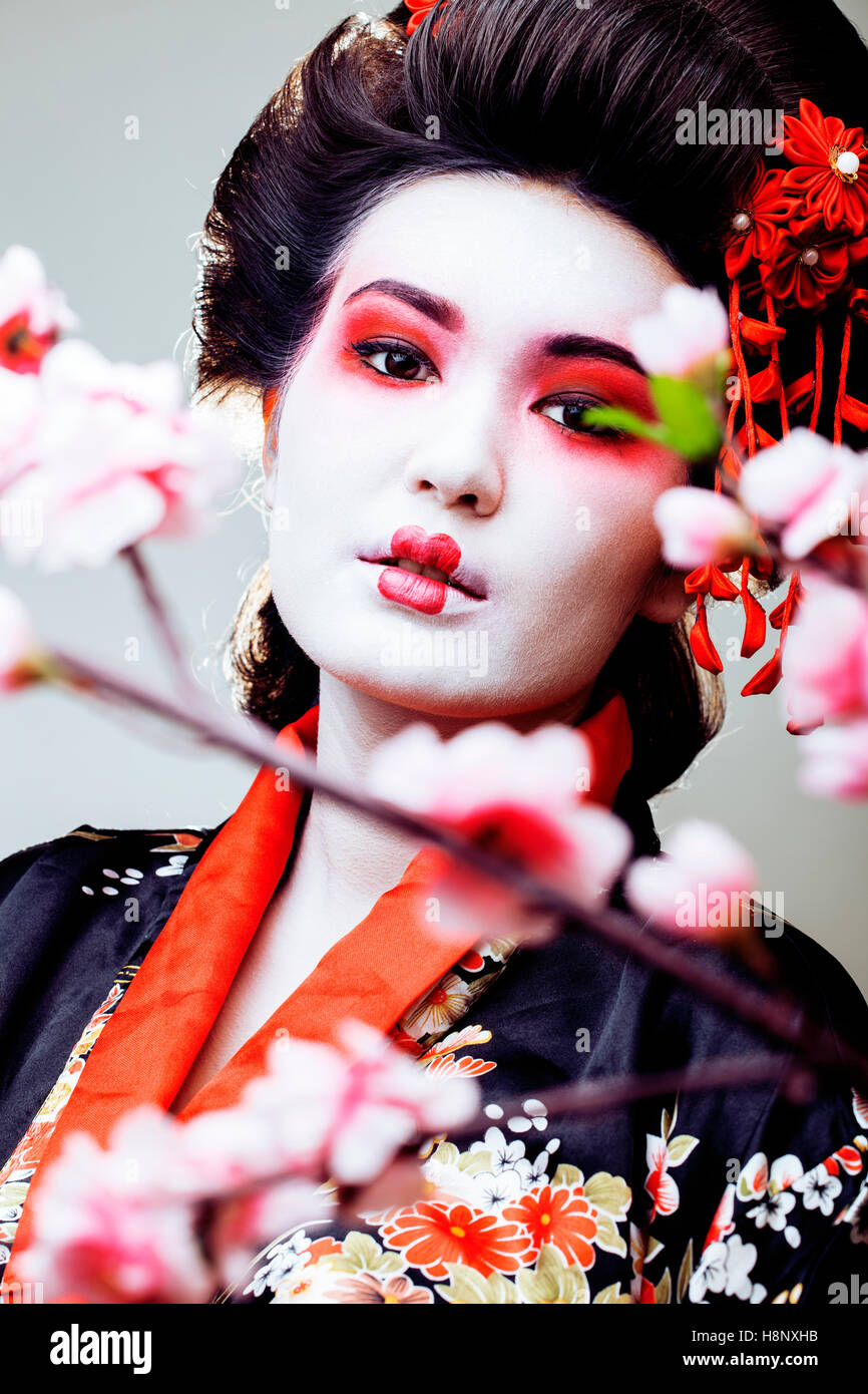 young pretty geisha in black kimono among sakura, asian ethno Stock ...
