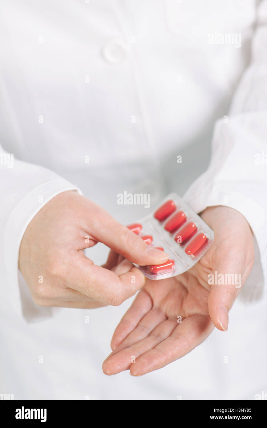 Female doctor offering red tablets to patient, healthcare and pharmacy ...