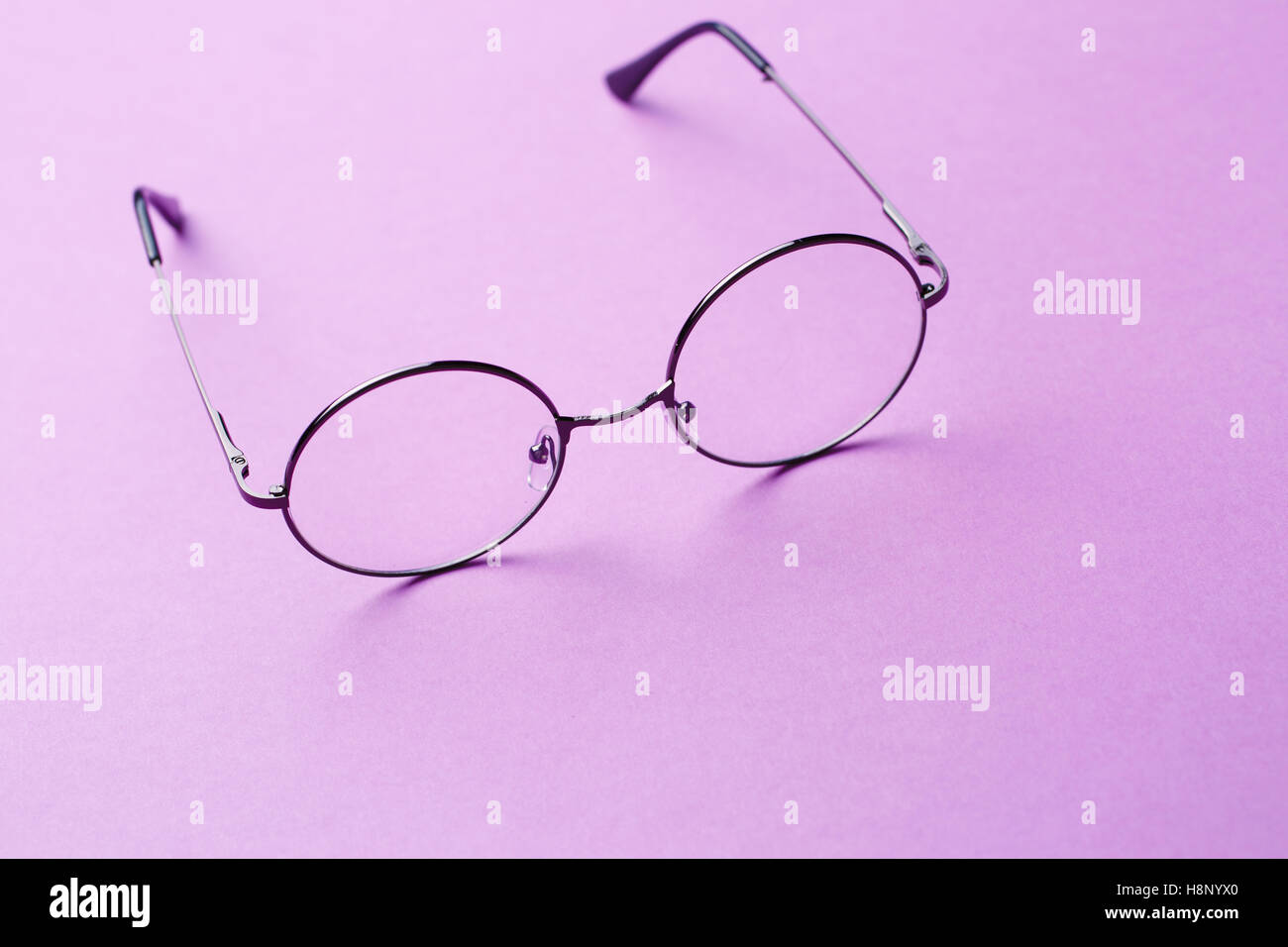Round glasses with transparent lenses on empty purple background Stock ...