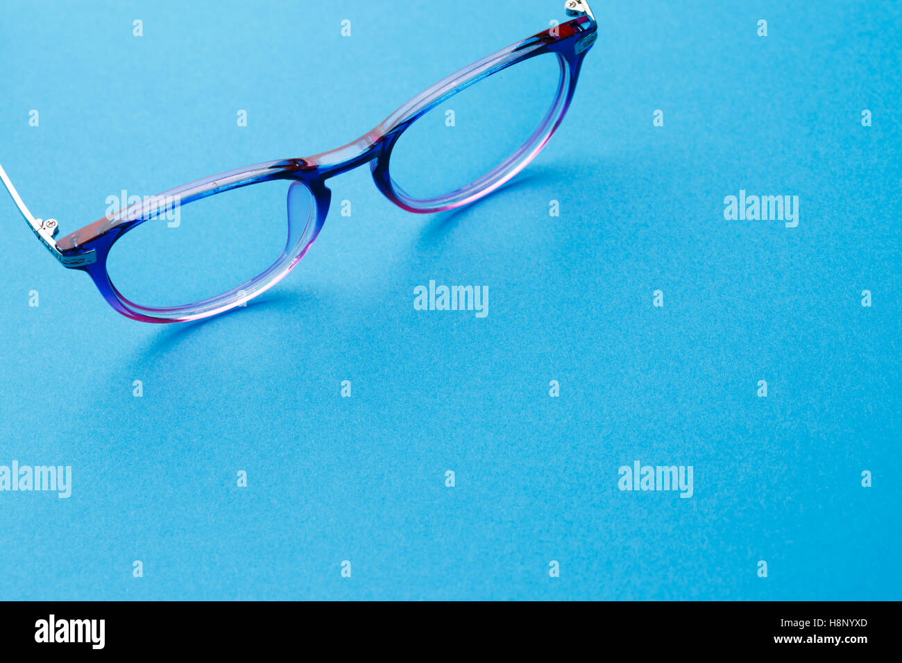Glasses with transparent glass on pure blue background Stock Photo - Alamy