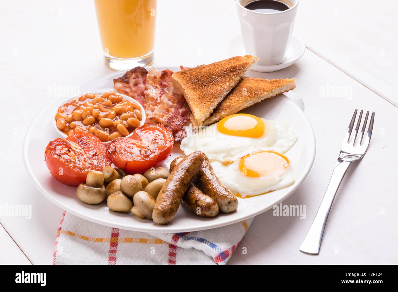 full english breakfast with bacon, sausage, eggs, beans, mushrooms, on ...
