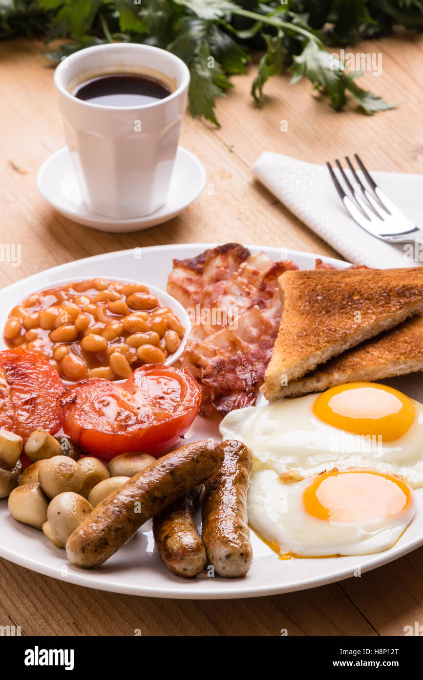 rustic full english breakfast with bacon, sausage, eggs, beans ...