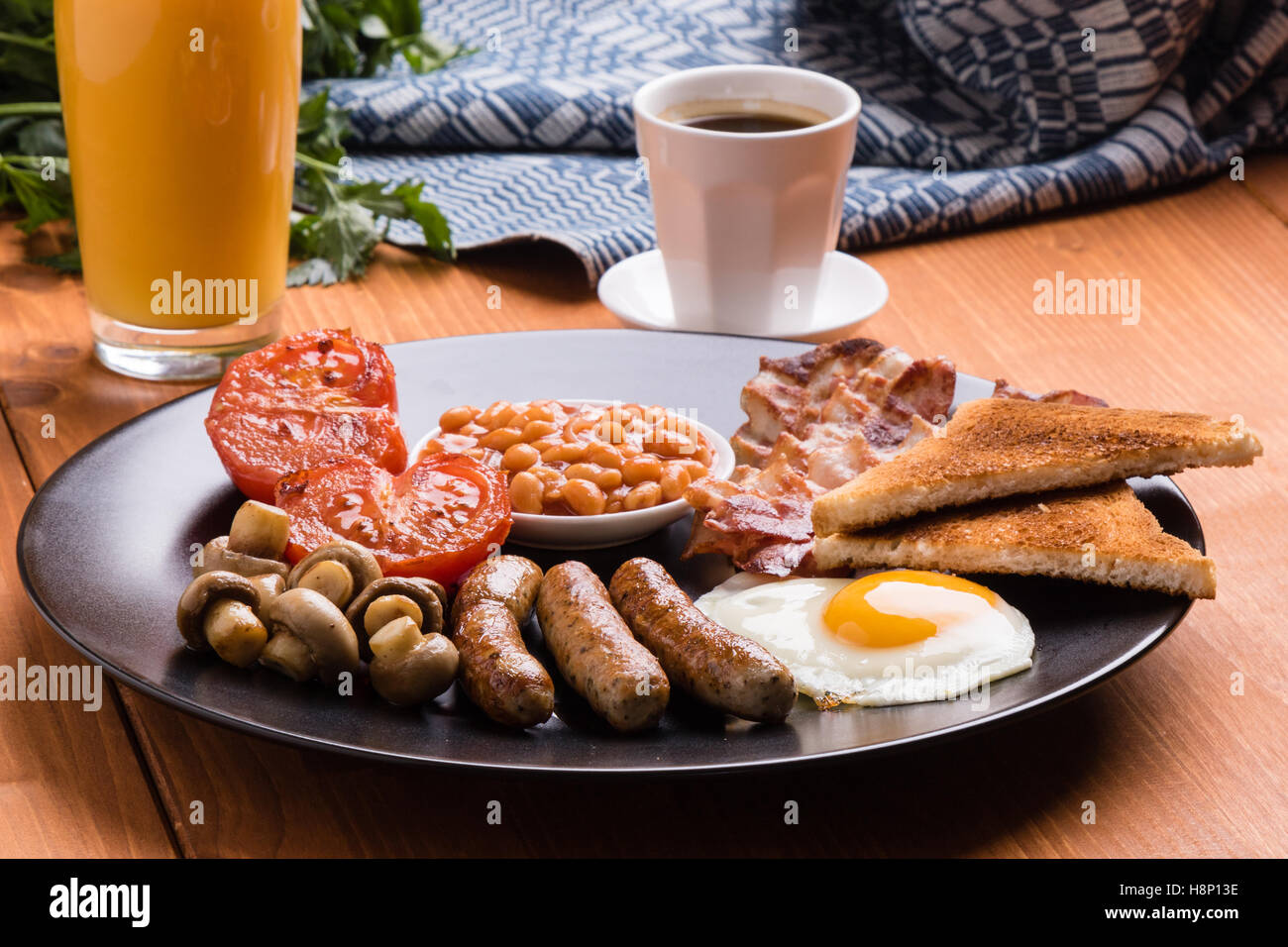 rustic full english breakfast with bacon, sausage, eggs, beans ...