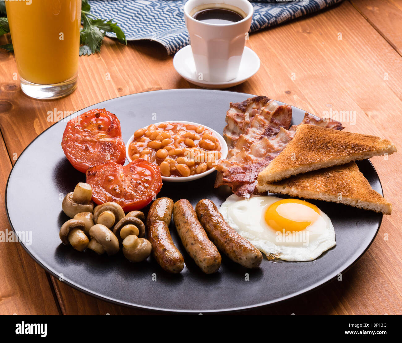 rustic full english breakfast with bacon, sausage, eggs, beans ...