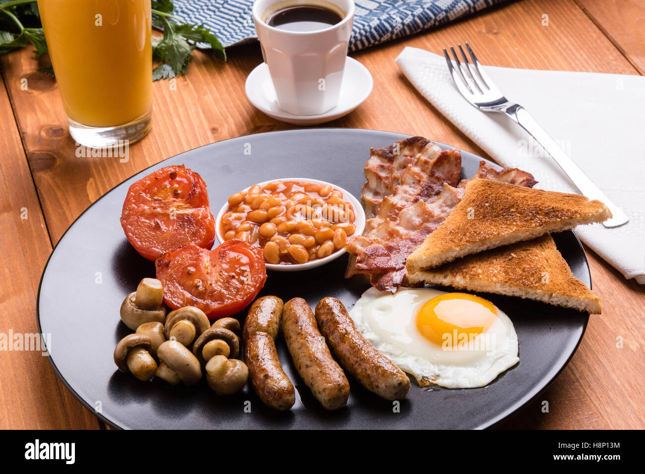 rustic full english breakfast with bacon, sausage, eggs, beans ...