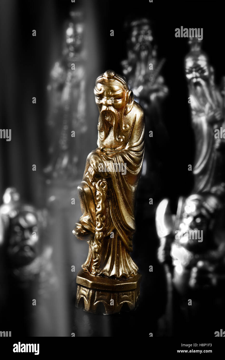 Chinese Emperor antique chess piece in gold against a dark background ...
