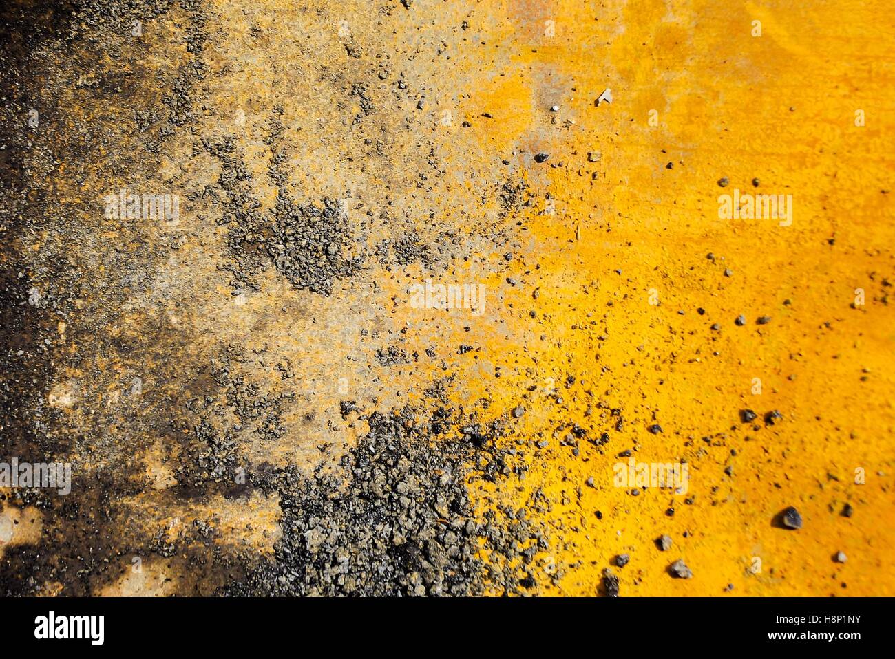 Weathered industrial yellow metal with gravel Stock Photo - Alamy