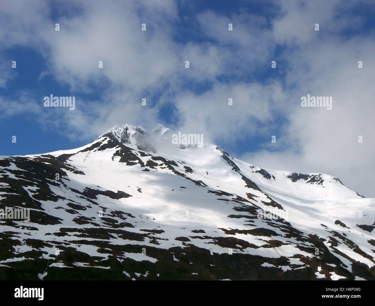 Clouds and Snow Blowing Over A Mountain Peak Stock Photo - Alamy