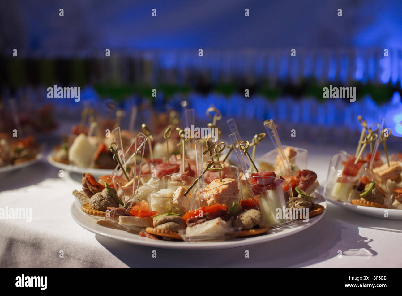 Catering banquet table with baked food snacks, sandwiches, cakes, cups ...