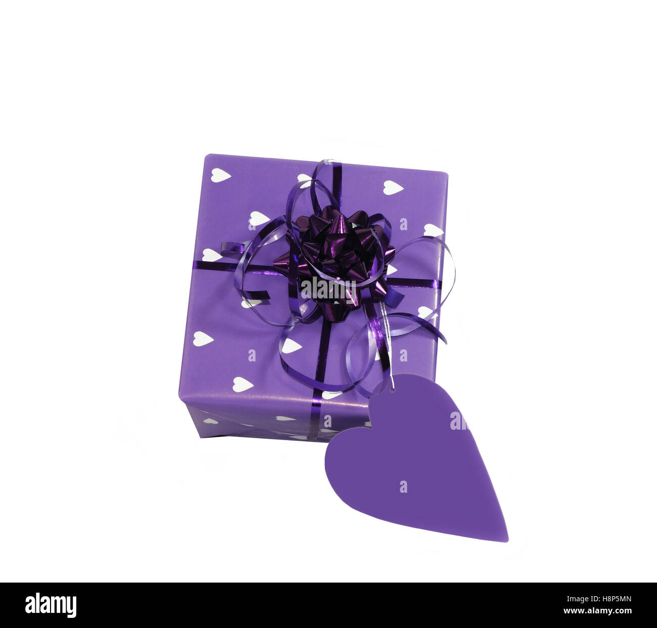 Gift wrapped in purple paper with white hearts, ribbon and bow Stock ...