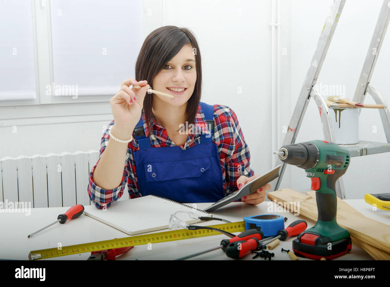 young woman carpenter sitting at desk in her workshop Stock Photo - Alamy