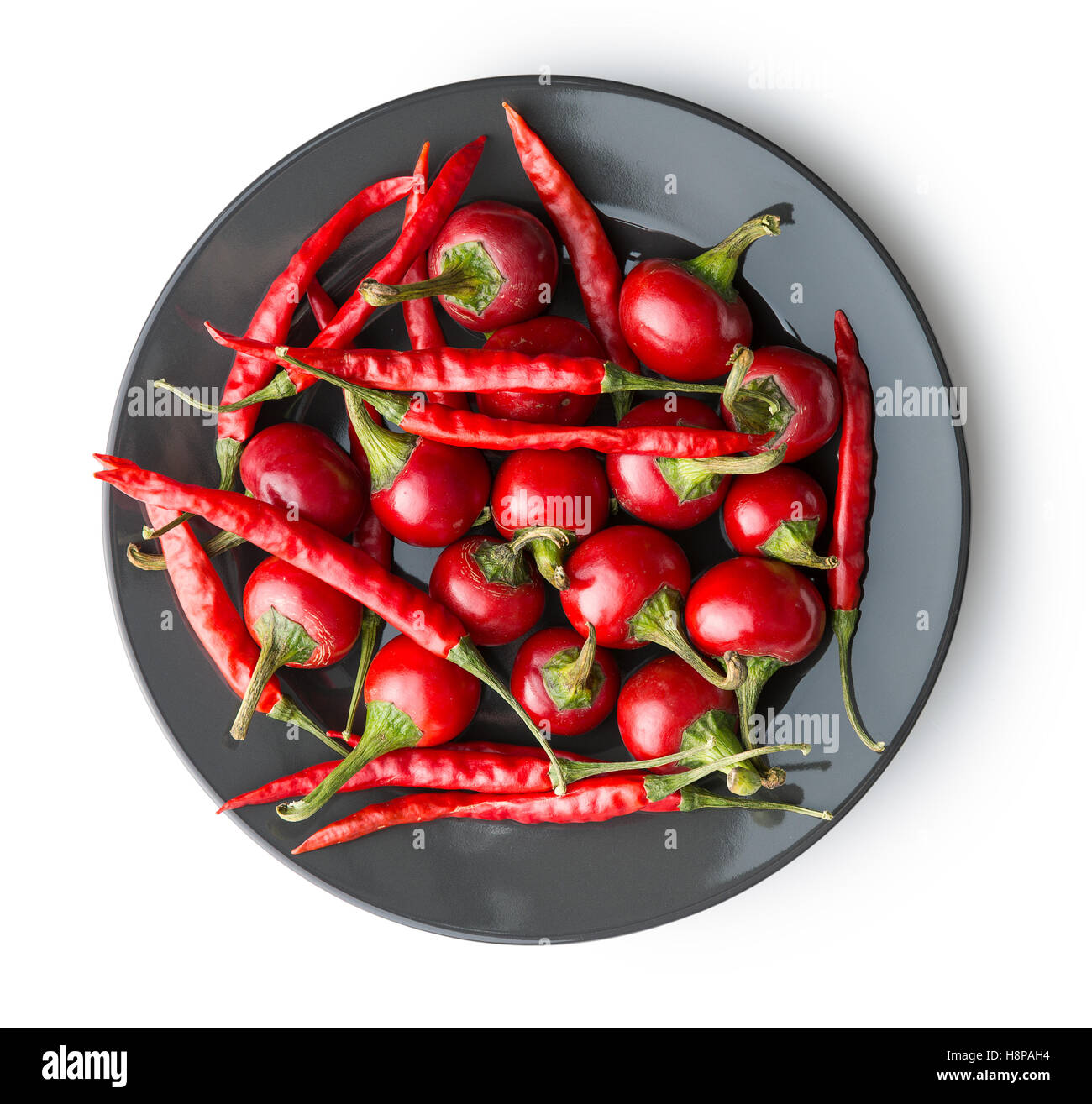 Red chili peppers on plate isolated on white background Stock Photo - Alamy