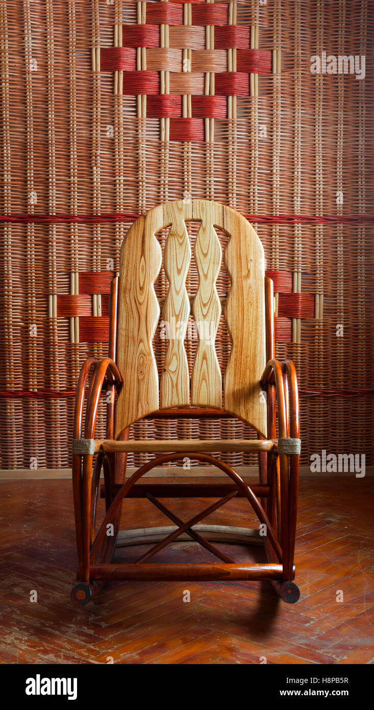 rocking chair made of wood on the wall background wicker, front view ...
