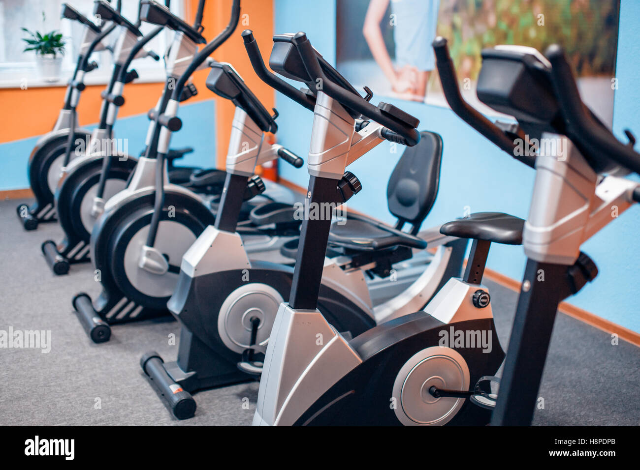 Aerobics spinning exercise bikes gym room with many in a row Stock ...