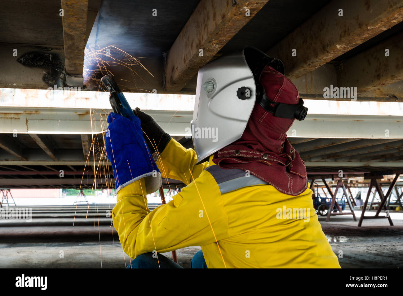 Industry worker with welding steel to repair container structures ...