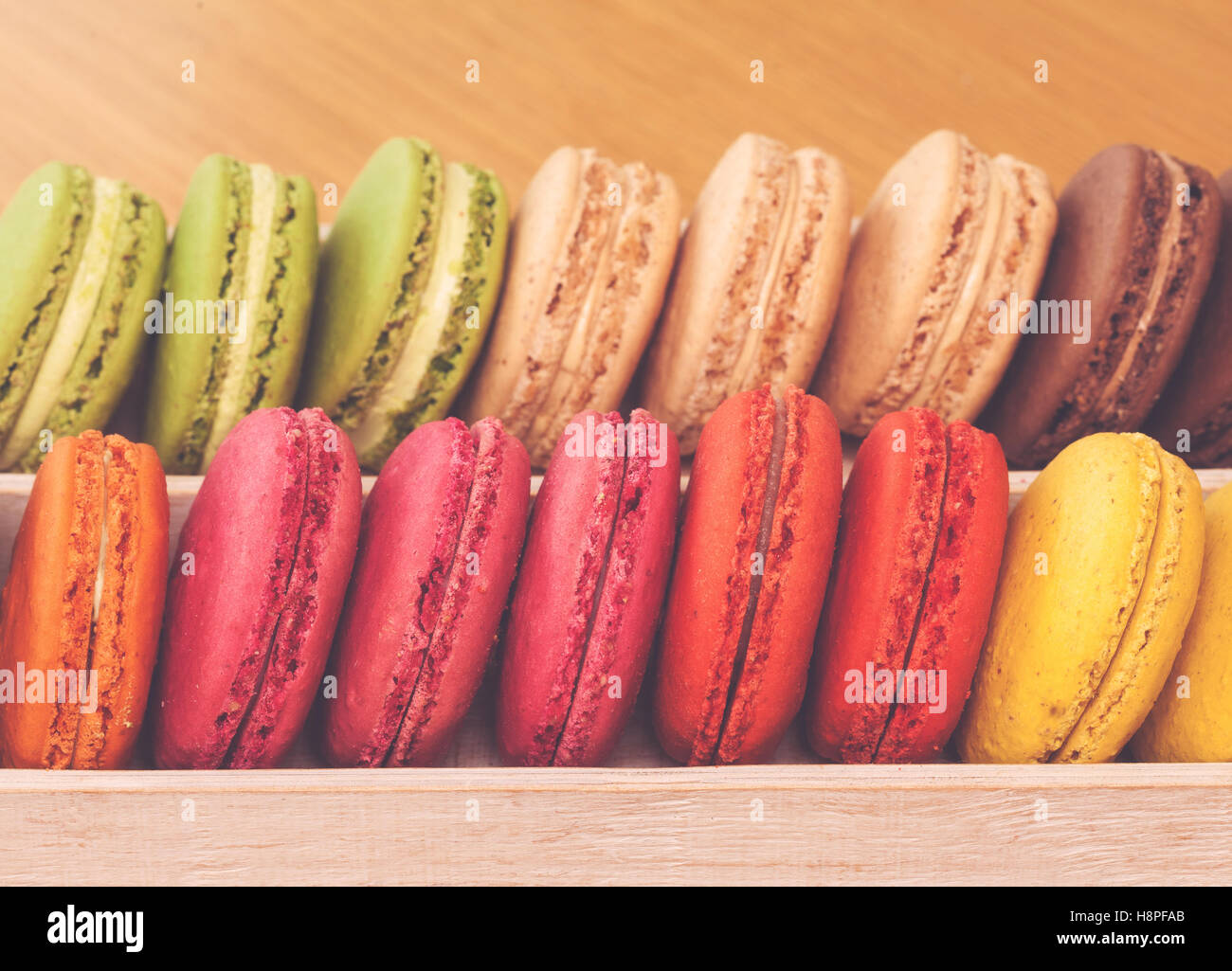 Row of traditional french colorful macarons in box, vintage toned Stock ...
