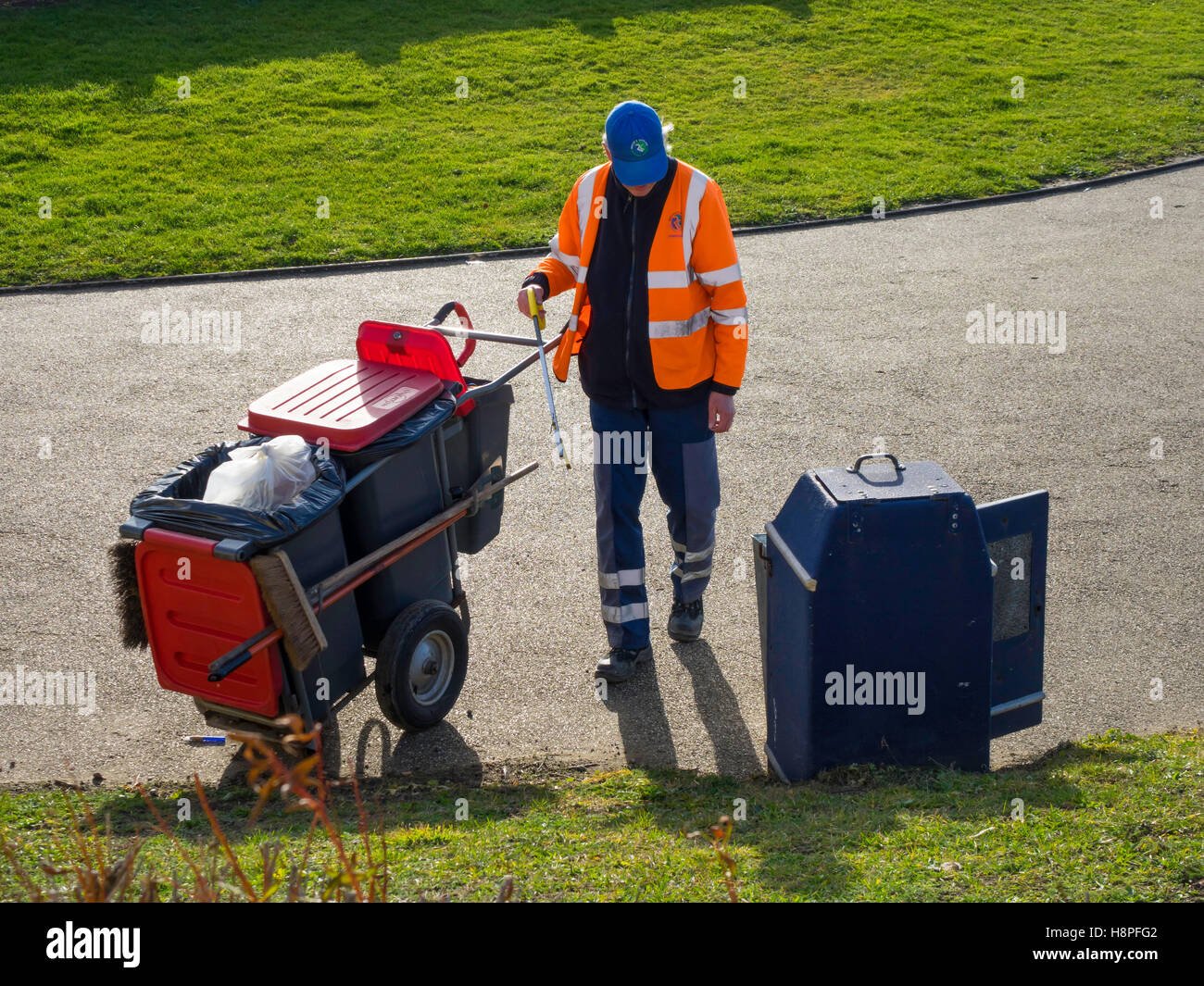 Street Cleaner emptying a waste rubbish bin in a small park Stock Photo ...