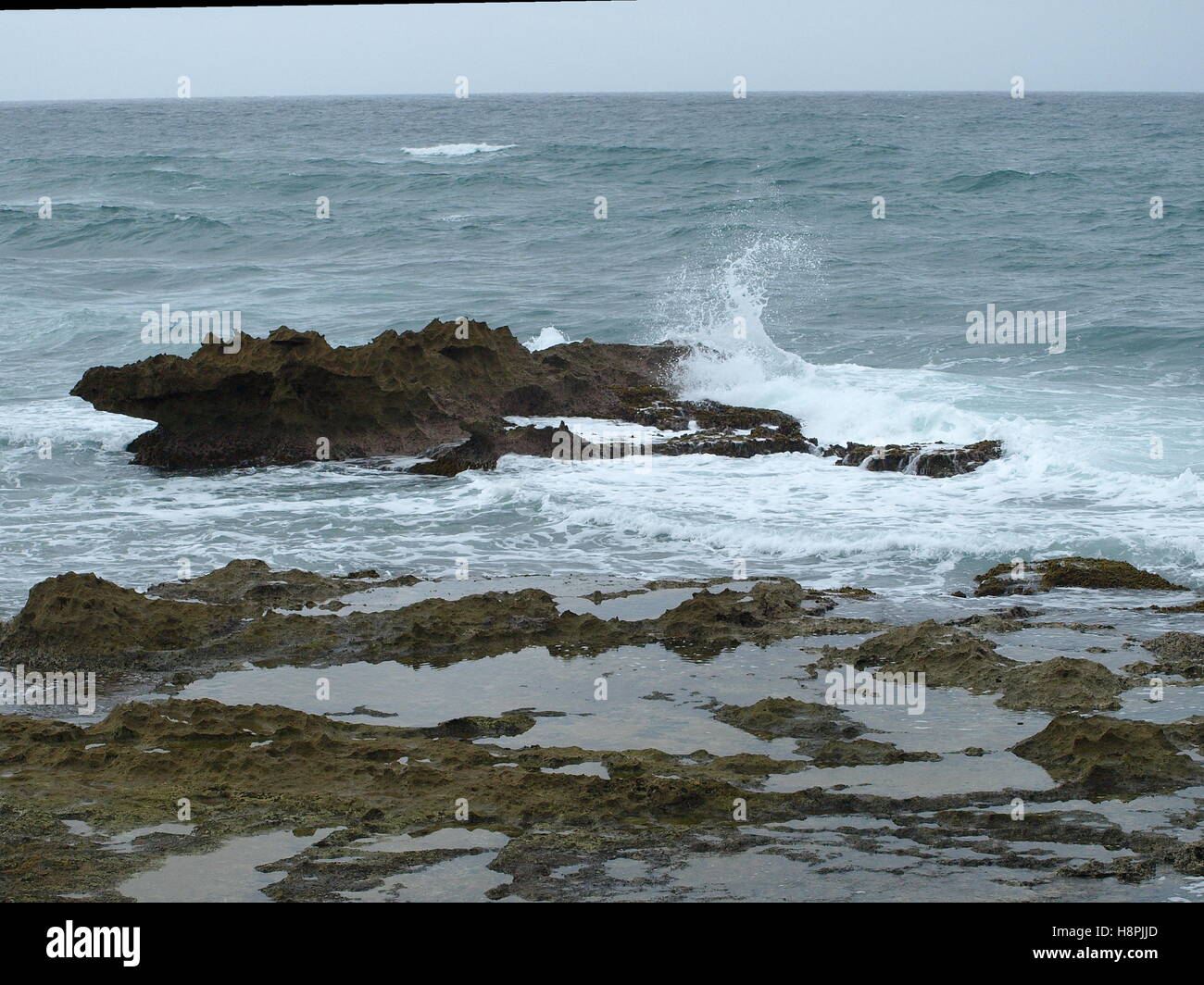 Wave Breaking on Rock Just off of Shore Line Stock Photo - Alamy