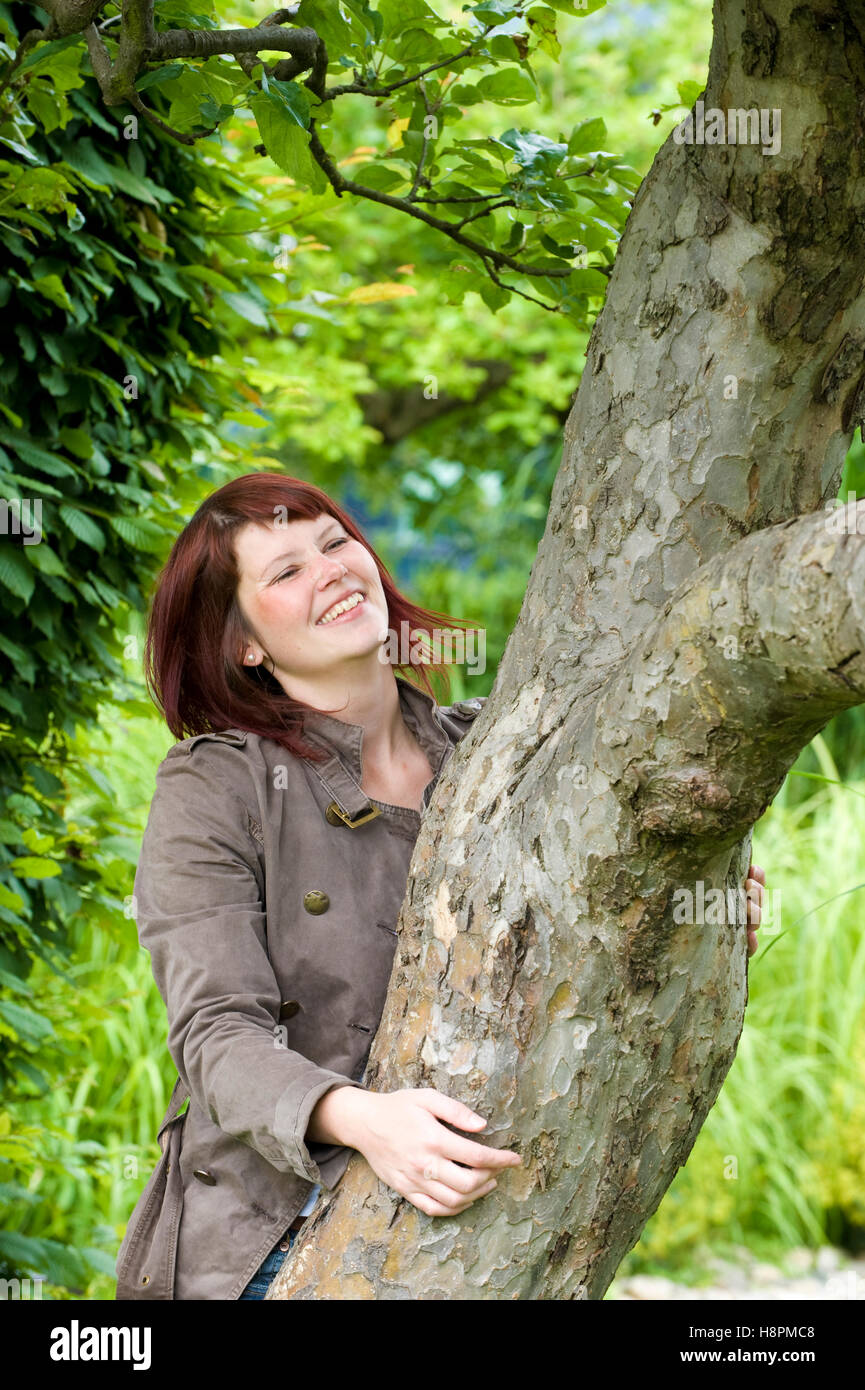 Happy woman, 25 +, hugging a tree Stock Photo - Alamy