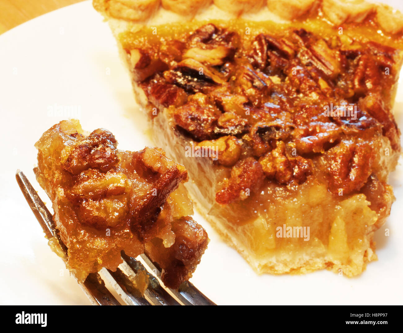 Pecan pie on a fork and white plate ready to disappear Stock Photo - Alamy