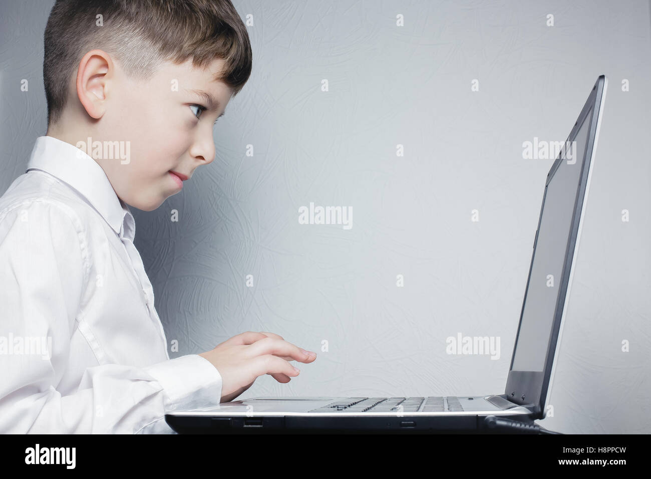 School child looking at computer over gray background Stock Photo - Alamy