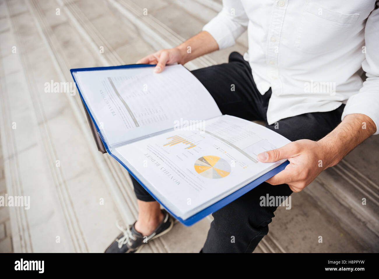 Closeup of businessman sitting and holding documents in folder Stock ...
