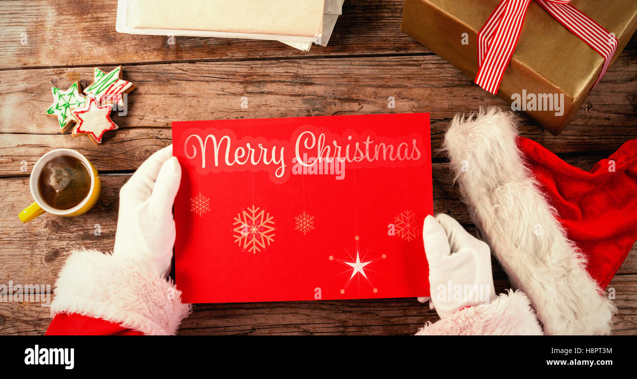 Composite image of santa claus holding a red placard Stock Photo - Alamy