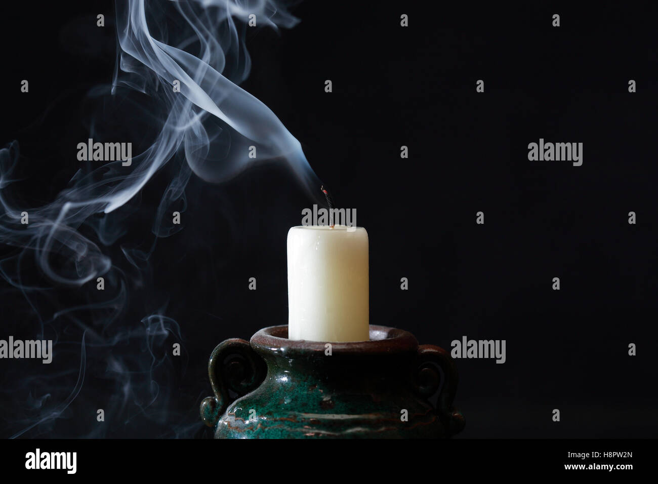 One extinguished candle with smoke on dark background Stock Photo - Alamy