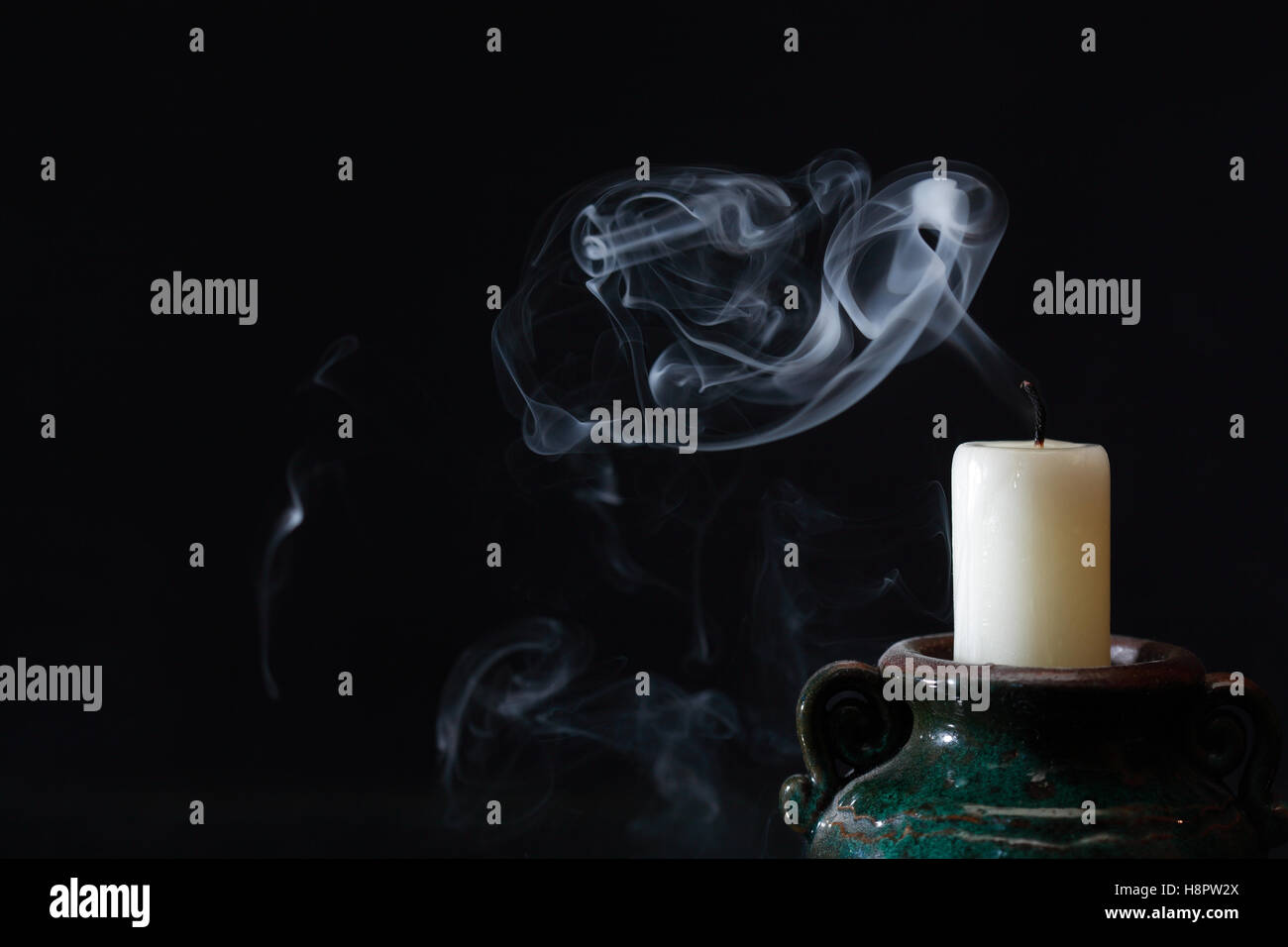 One extinguished candle with smoke on dark background Stock Photo - Alamy