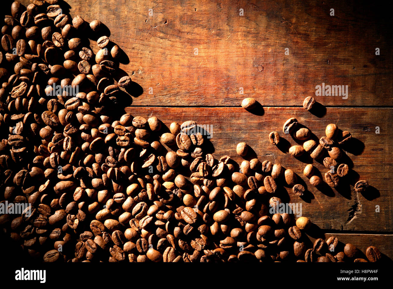 Coffee beans on nice wooden background under beam of light Stock Photo ...