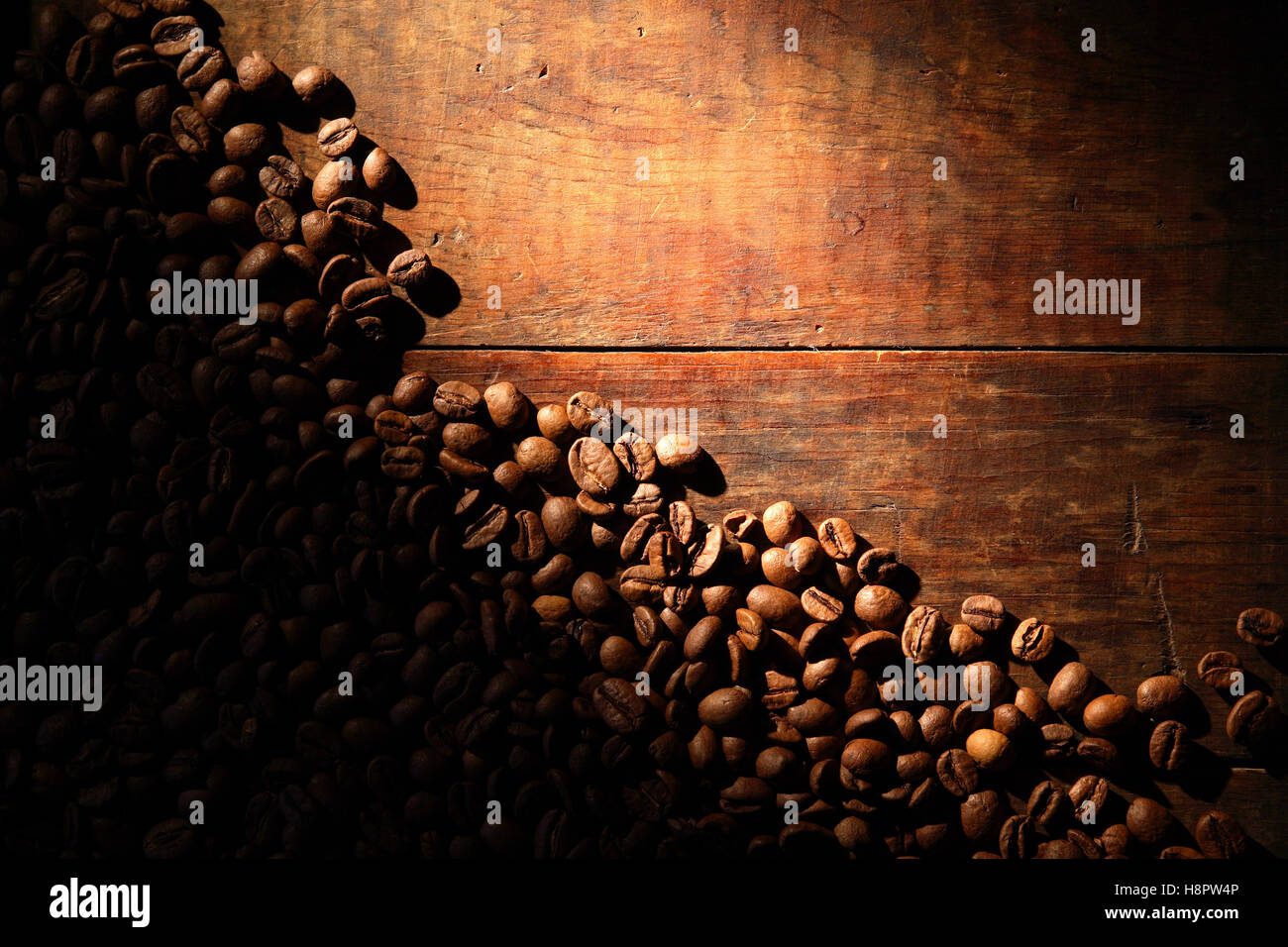 Coffee beans on nice wooden background under beam of light Stock Photo ...