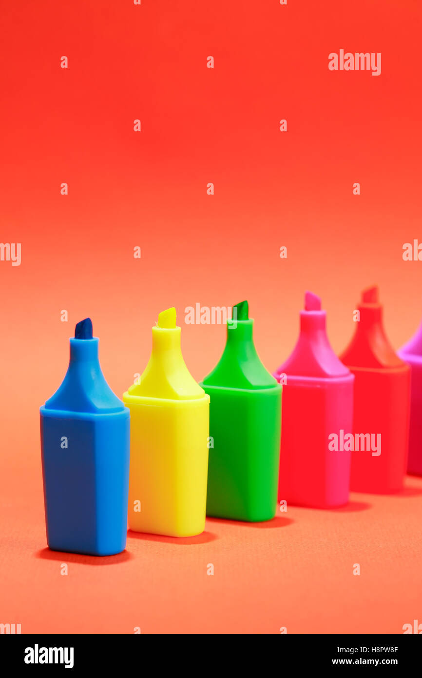 Set of color markers in a row on nice red background Stock Photo - Alamy