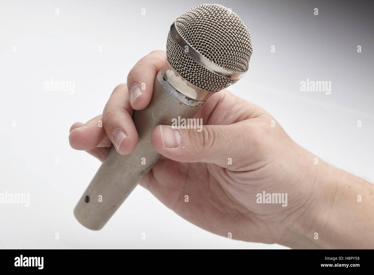 Microphone in a man's hand Stock Photo - Alamy