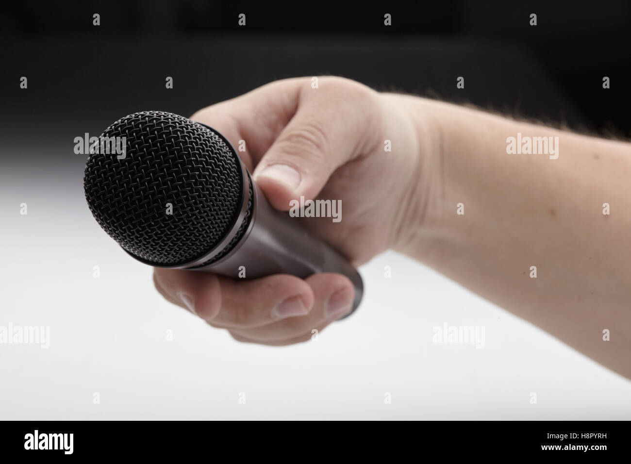Microphone in a man's hand Stock Photo - Alamy
