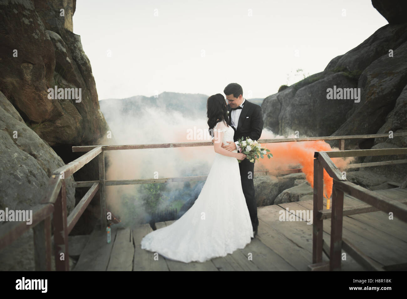 Wedding couple in love kissing and hugging near rocks on beautiful ...