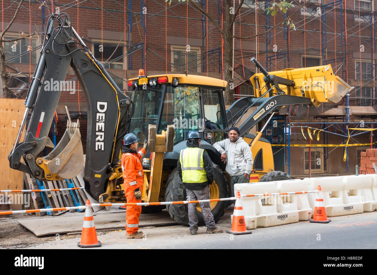 John Deere 410J with construction workers on a work site in New York ...