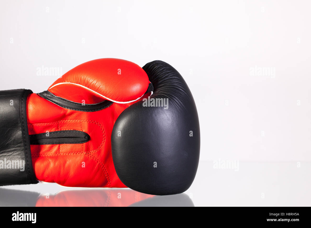 Red and black boxing gloves on a glass table isolated on white ...
