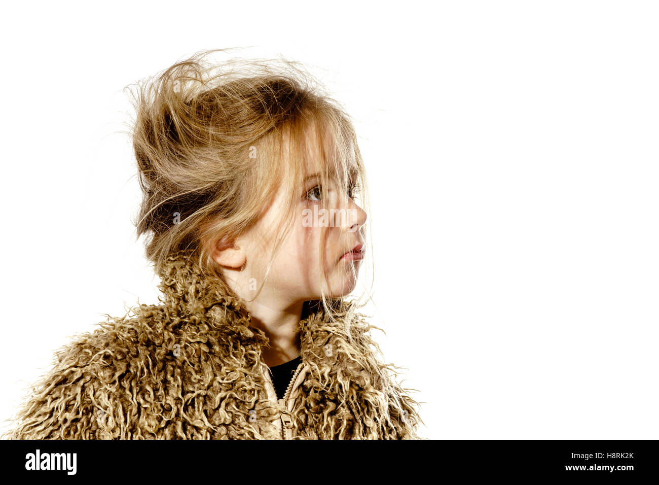 Disheveled preschooler girl with long hair dressed in fur coat ...